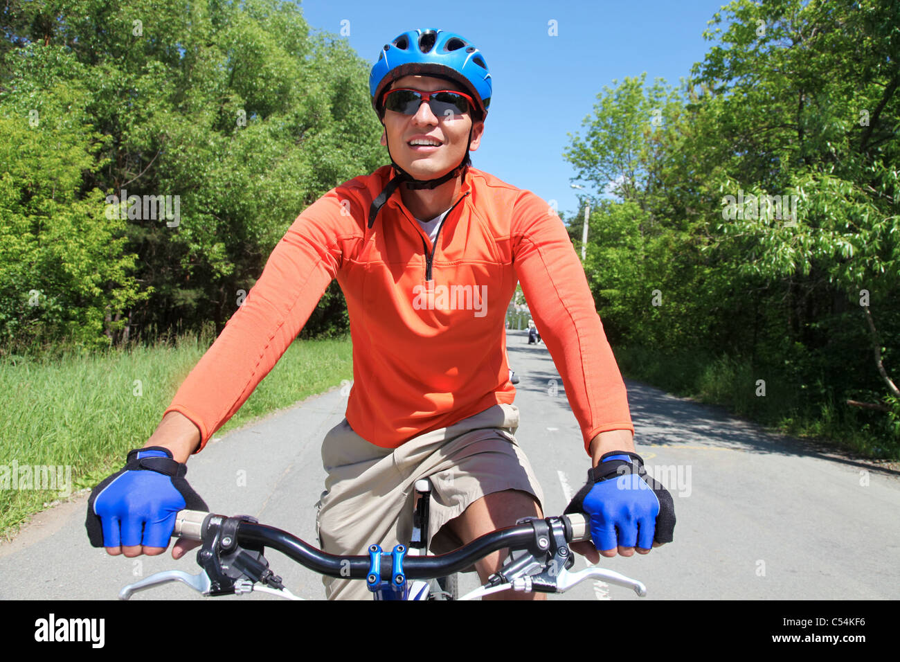 Portrait of a handsome man riding a bike Stock Photo - Alamy