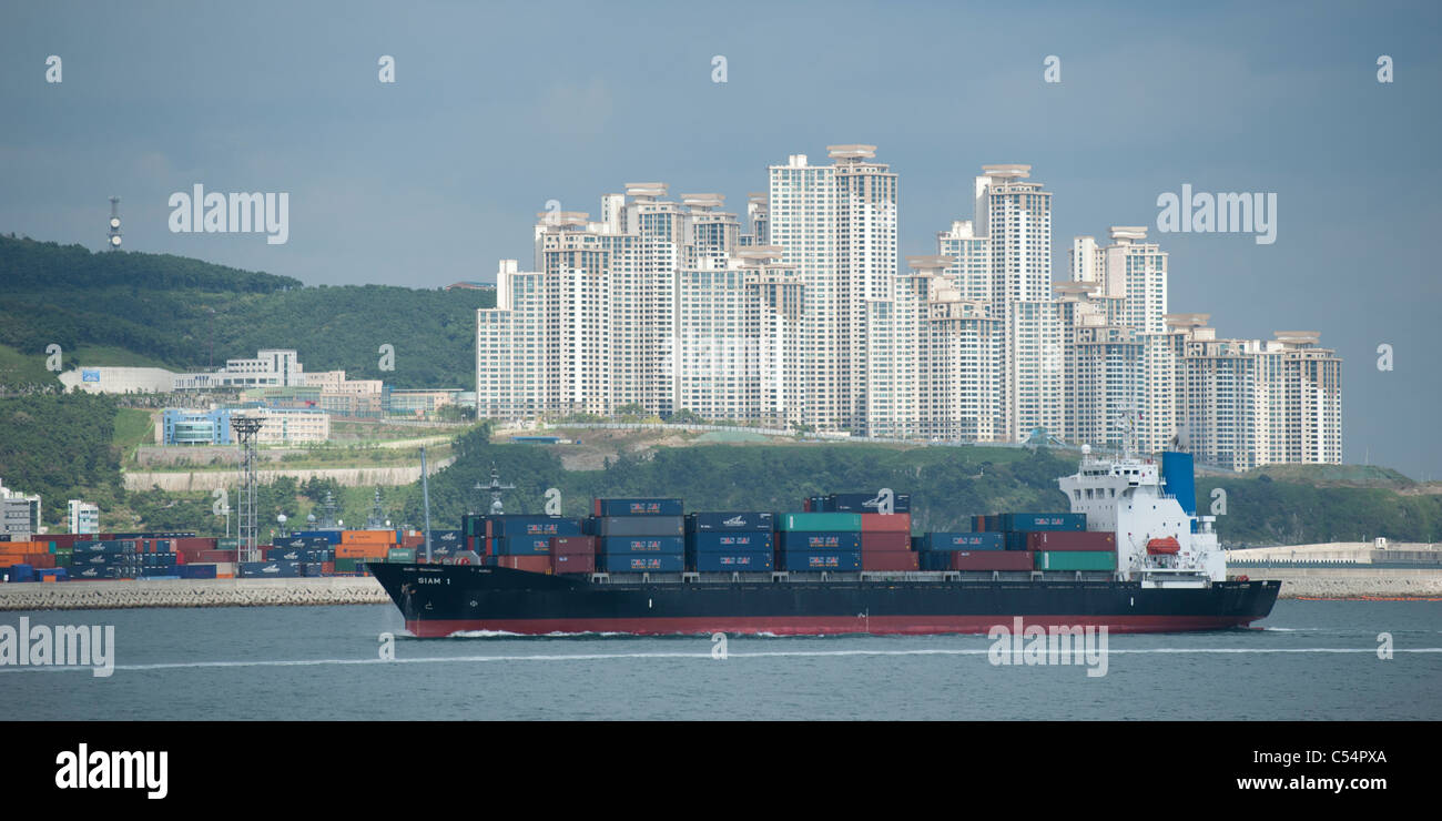 Container ship in the sea with skyscrapers in the background, Busan ...