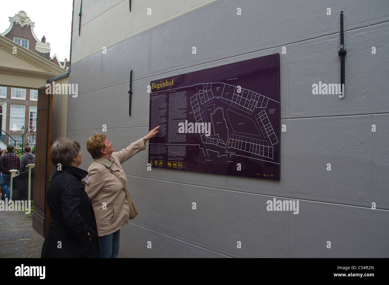 Tourists looking at map of Begijnhof the old inner city courtyard ...