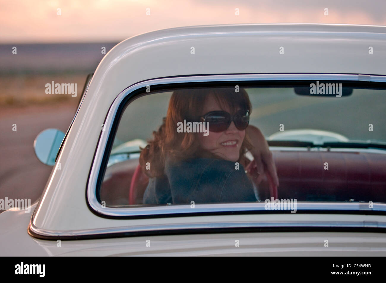Woman driving 1957 Ford Thunderbird at dusk, Mesa Del Sol, Albuquerque ...