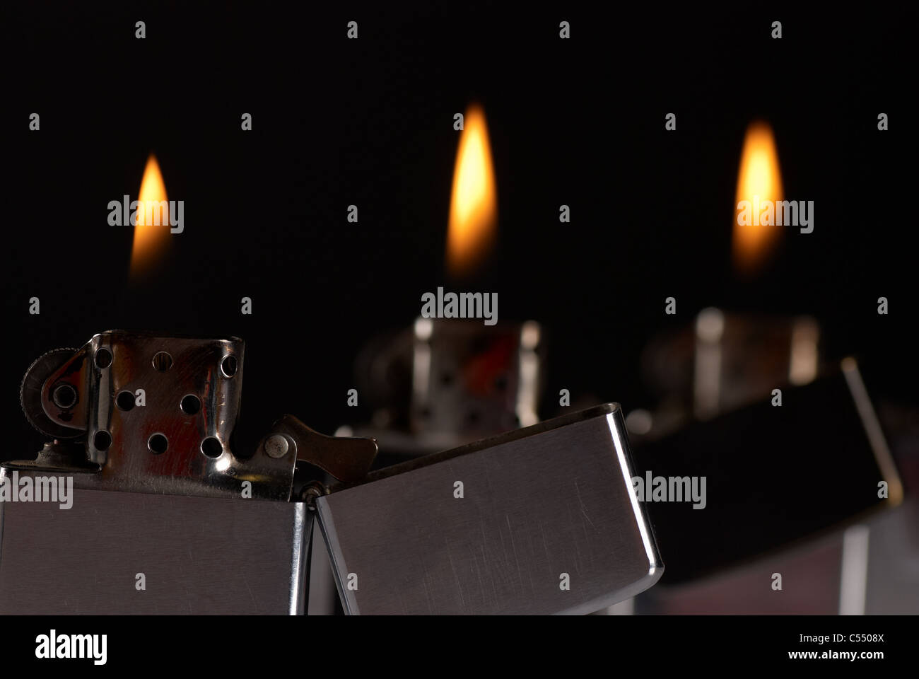 Several classic metal lighters isolated on black Stock Photo - Alamy