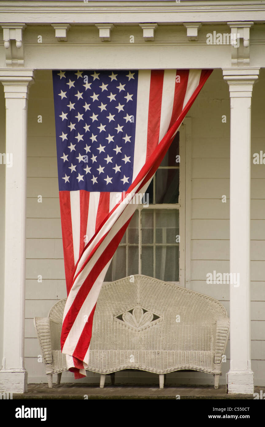 American flag hanging on the porch of a building Stock Photo - Alamy