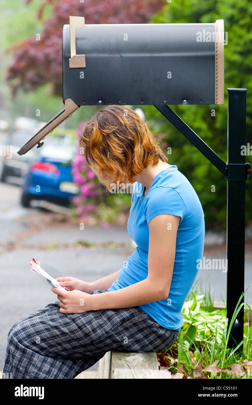 Teenage Girl reading the mail by the mailbox Stock Photo - Alamy