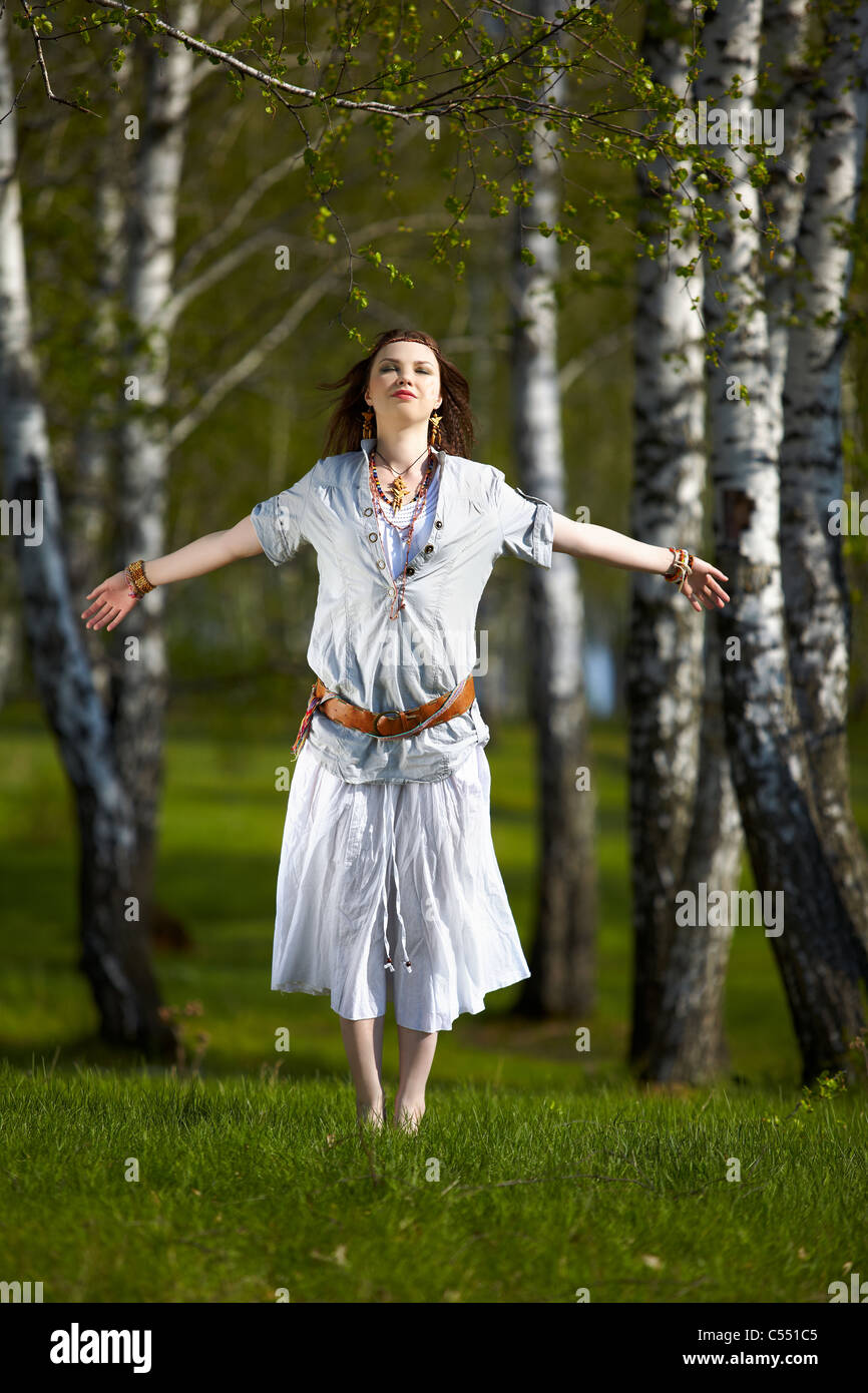 outdoor portrait of beautiful hippie girl jumping on green grass in ...