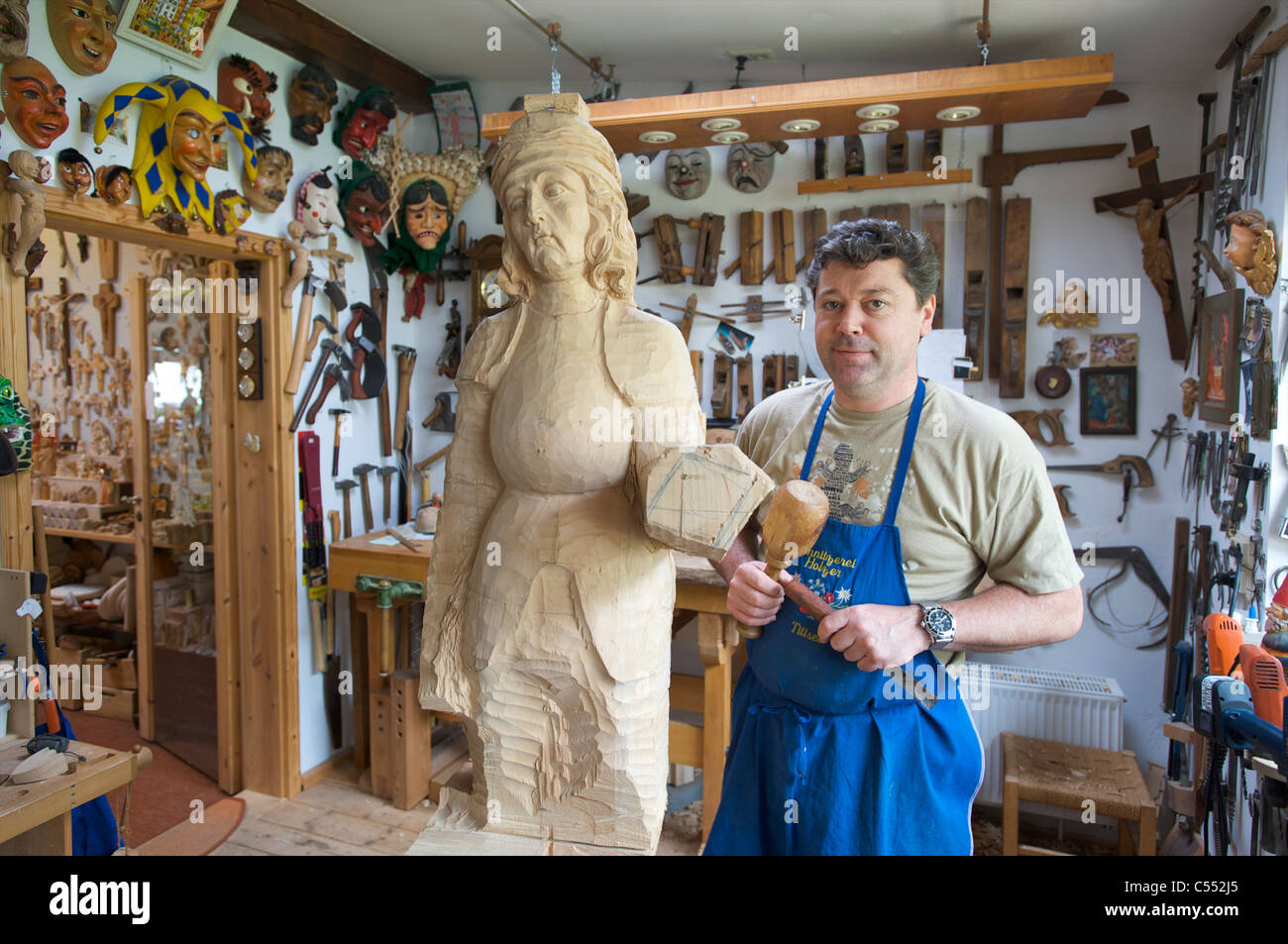Wood carver working on a large sculpture in his workshop in Titisee ...