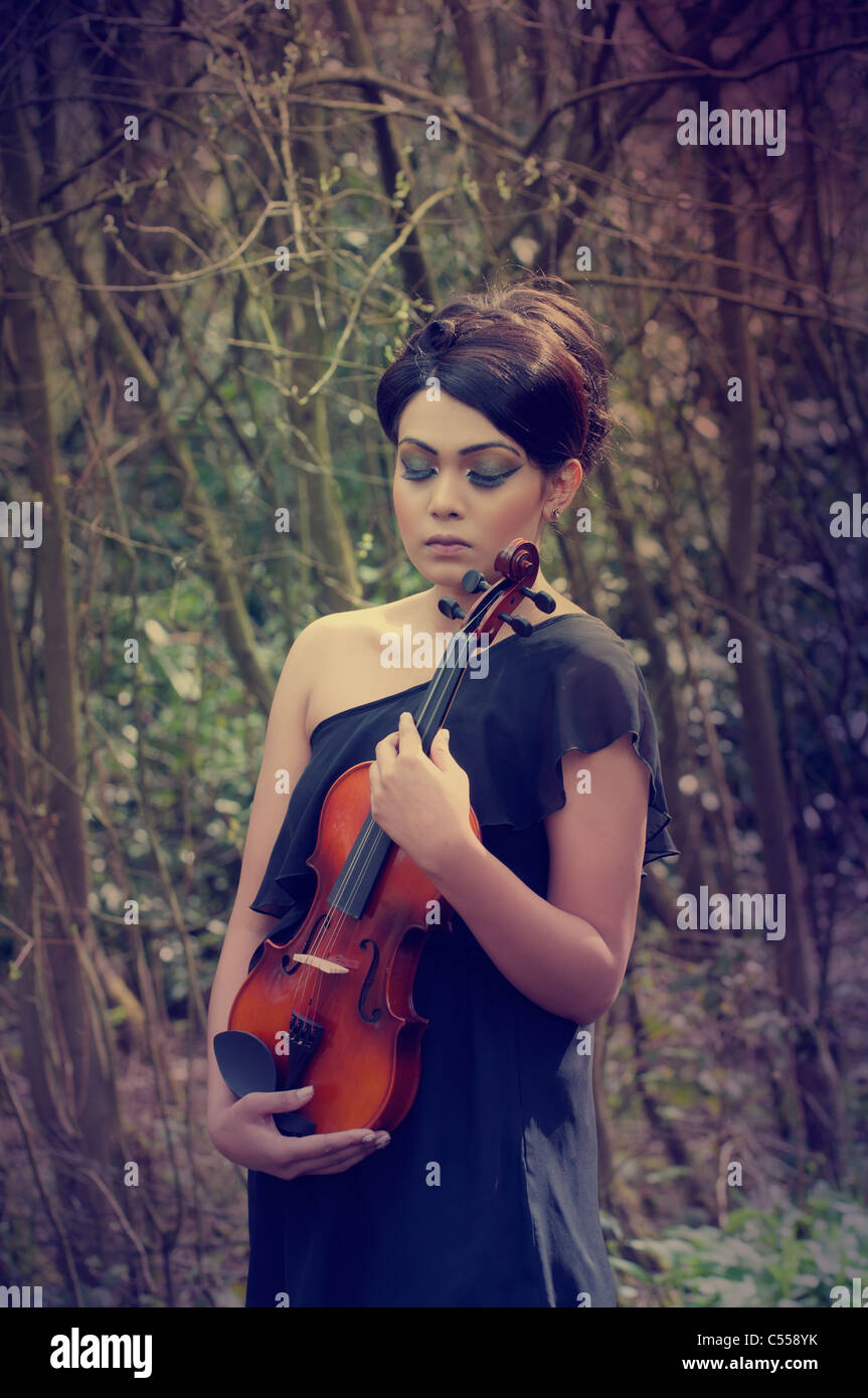Beautiful Asian woman holding a violin standing in the forest Stock ...