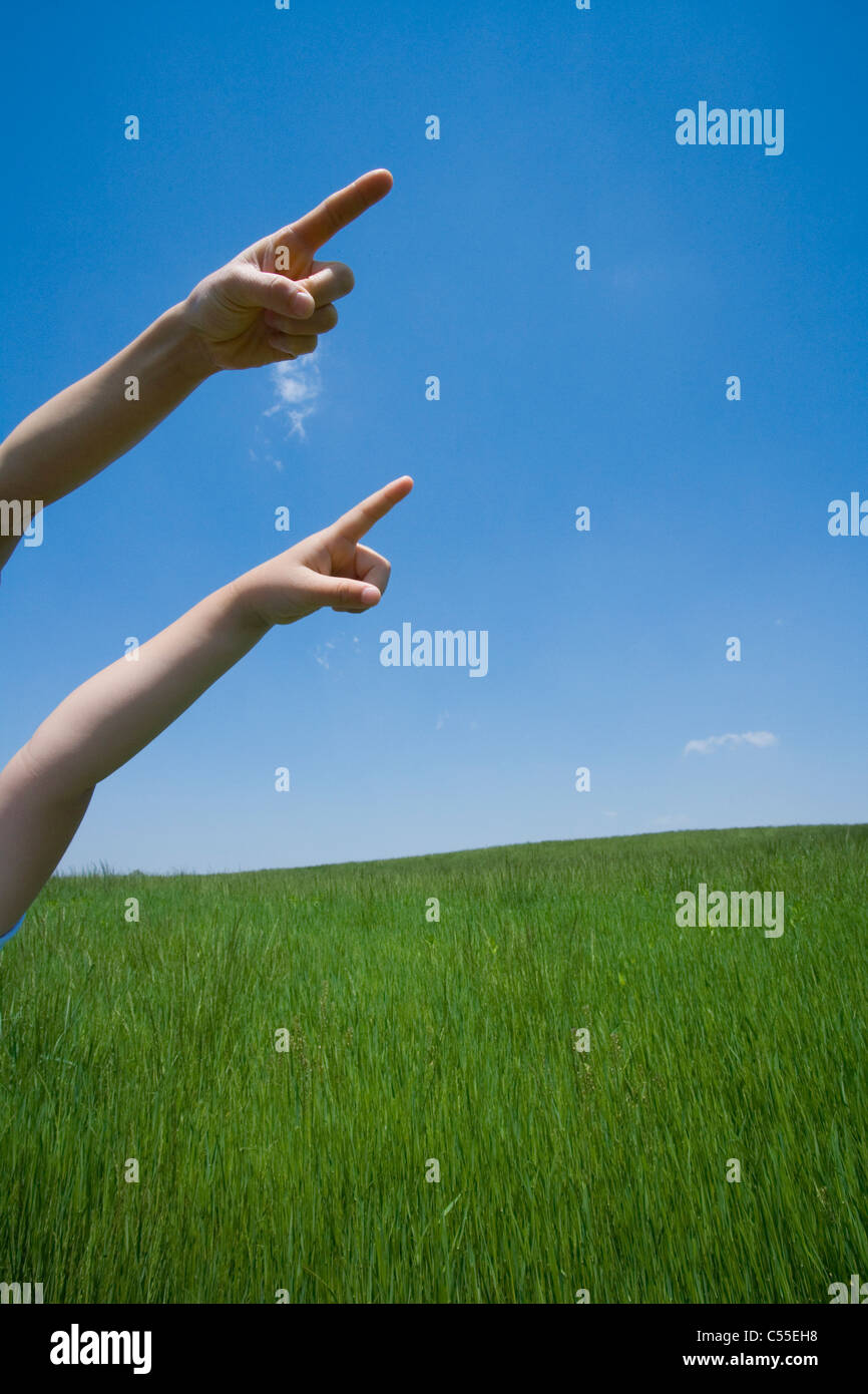 Two hands pointing at the sky on a grass field Stock Photo - Alamy