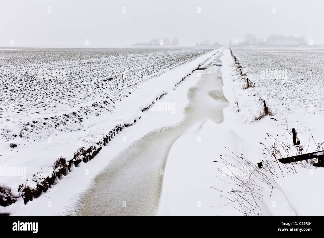 The Netherlands, Uithuizen, Snow in canal with farm in background Stock ...