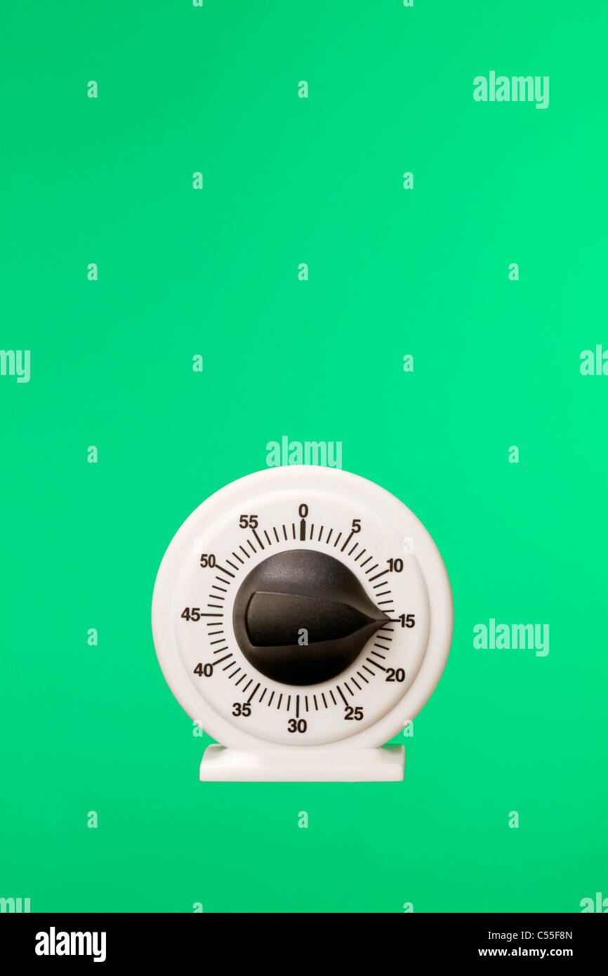 Plastic timer on a green background Stock Photo - Alamy