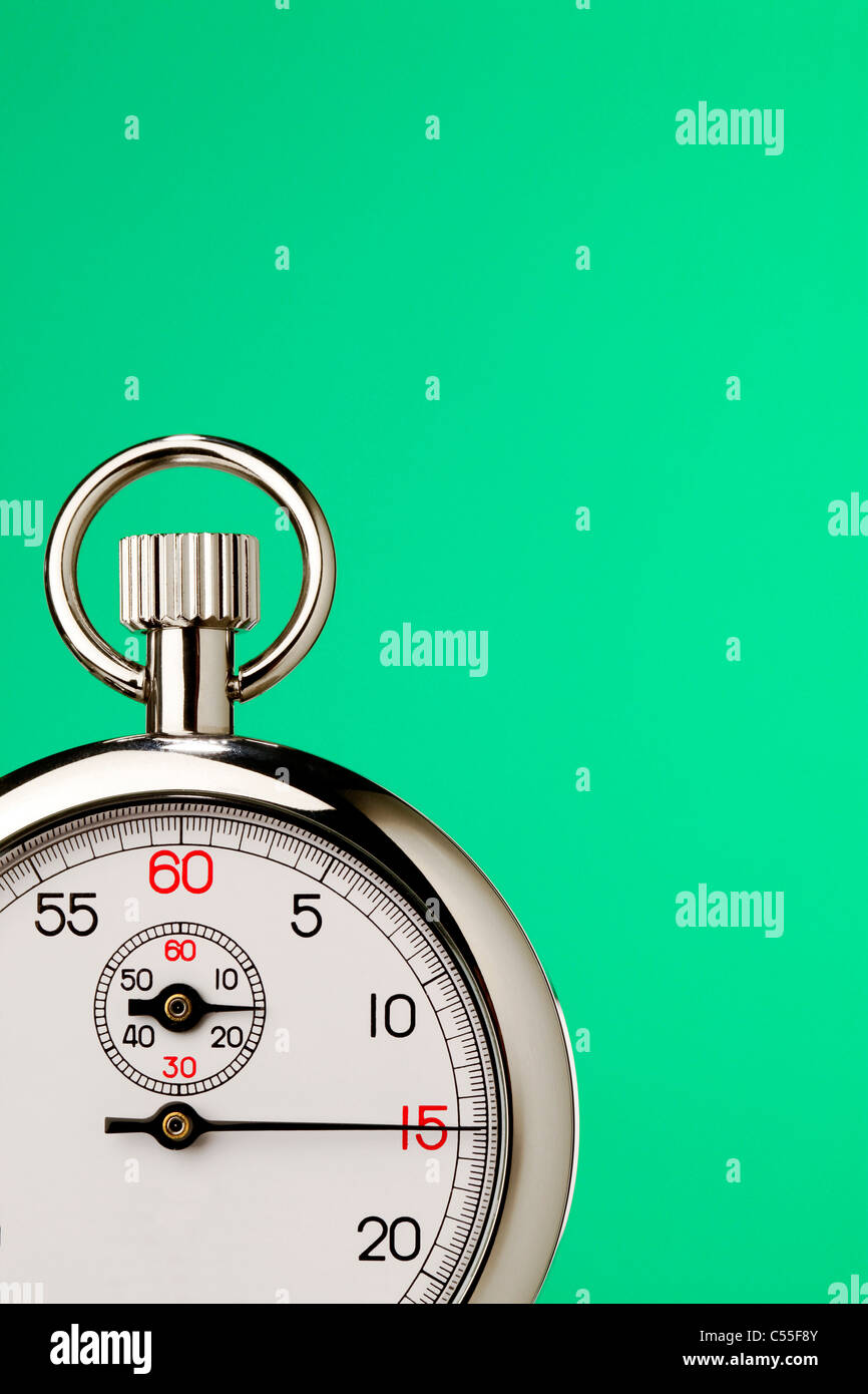 Stopwatch against green background Stock Photo - Alamy