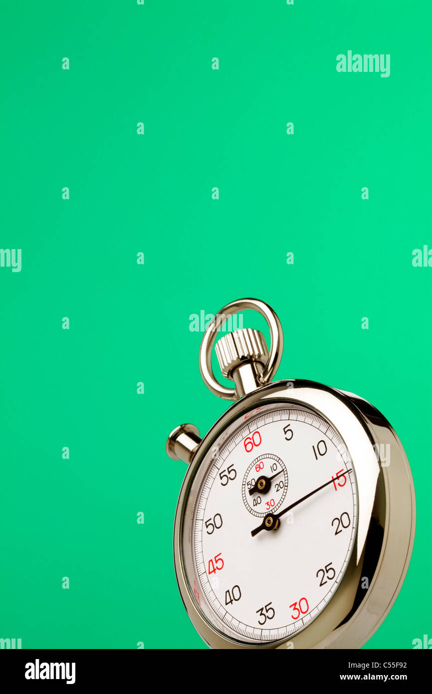 Stopwatch against green background Stock Photo - Alamy