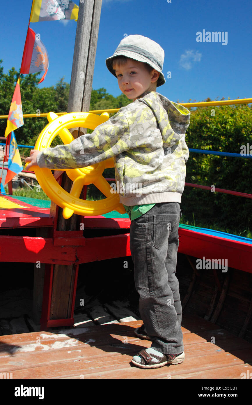 Young captain behind the toy steer wheel Stock Photo - Alamy