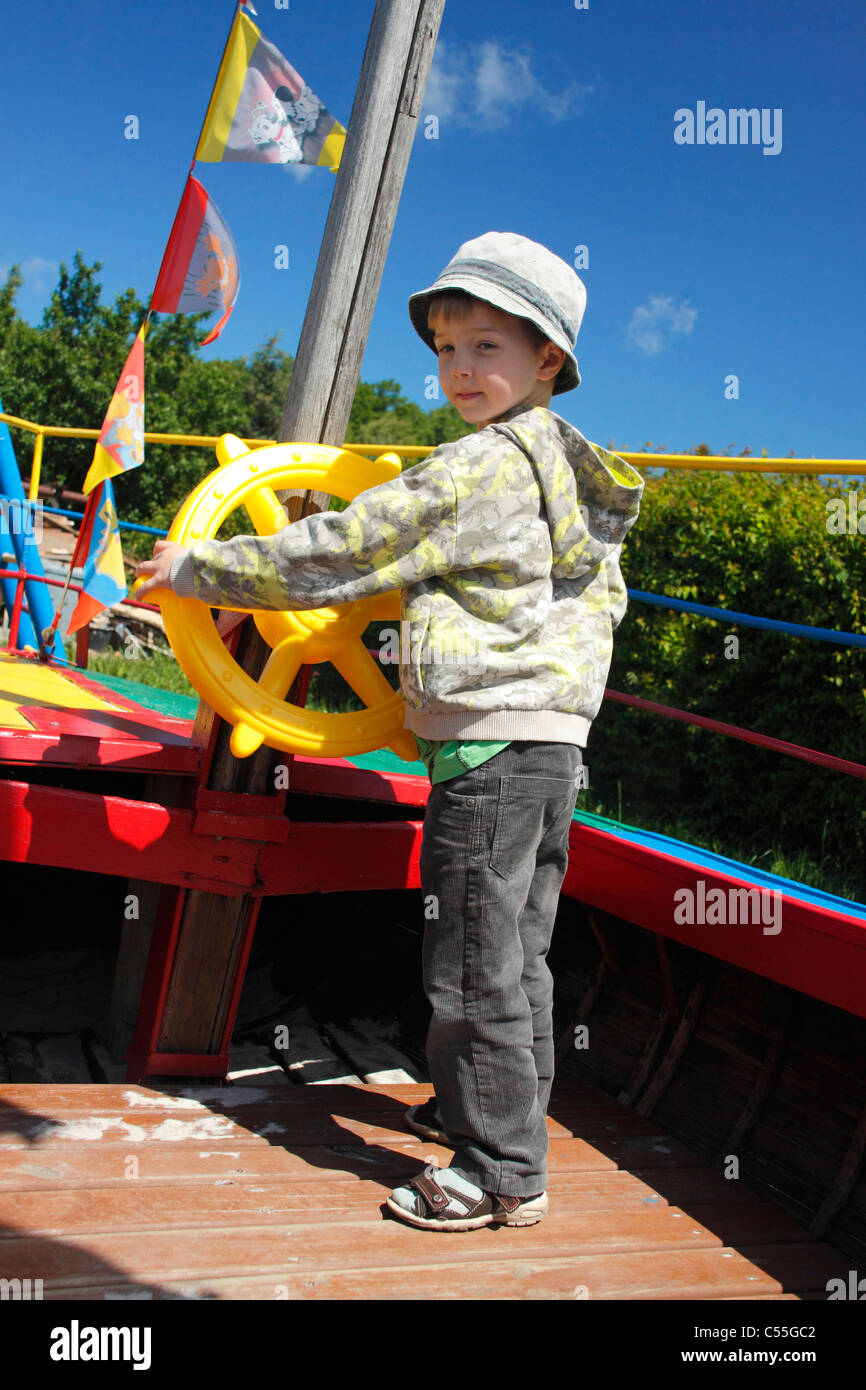 Young captain behind the toy steer wheel Stock Photo - Alamy