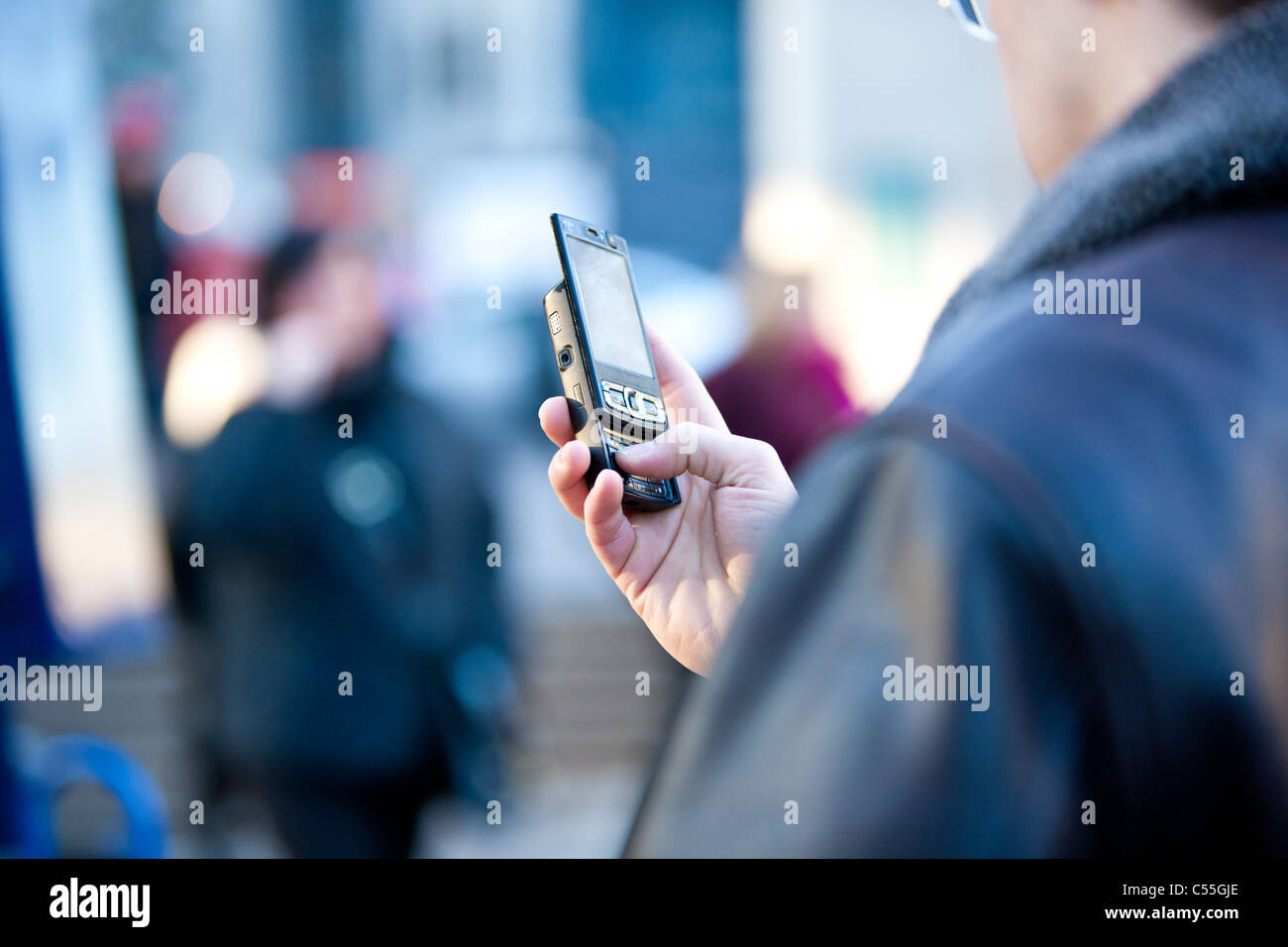 person on slide phone texting in public Stock Photo - Alamy