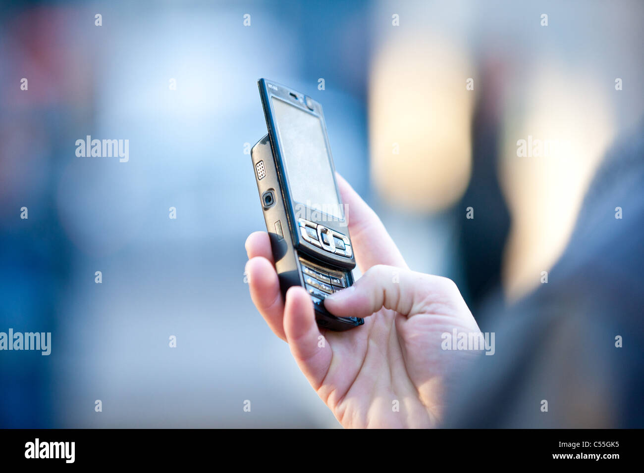 slide phone Person texting on smart phone in public Stock Photo - Alamy