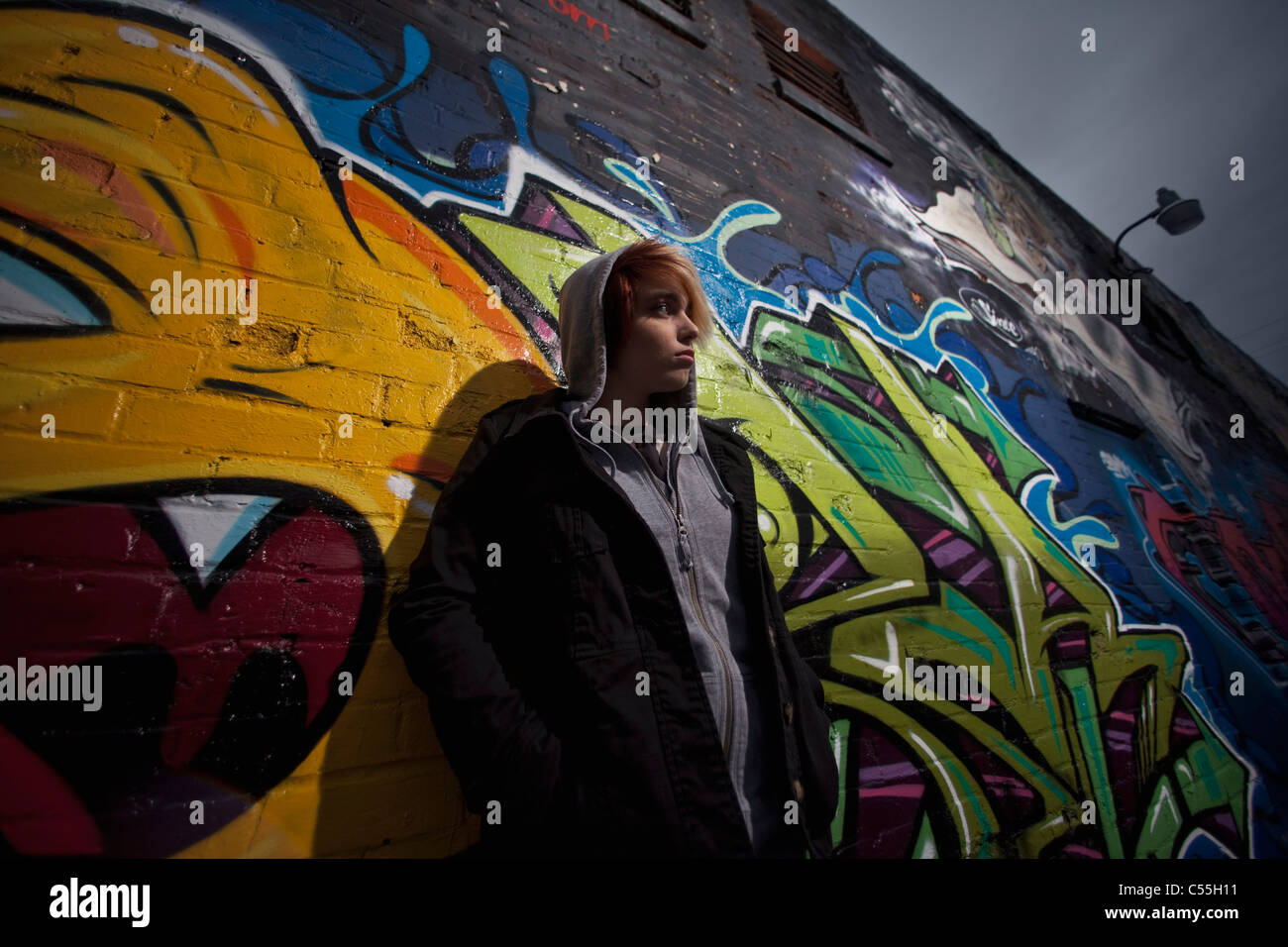 Sad punk girl standing by graffiti wall Stock Photo - Alamy