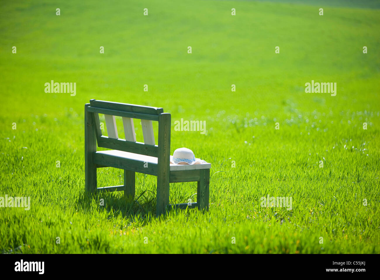 bench with a hat in green field Stock Photo - Alamy