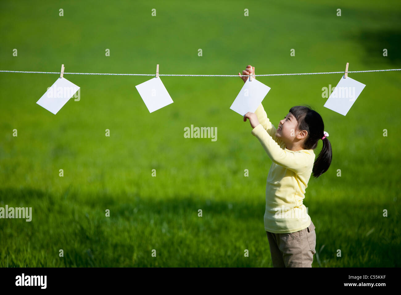 girl picks a paper from a string Stock Photo - Alamy