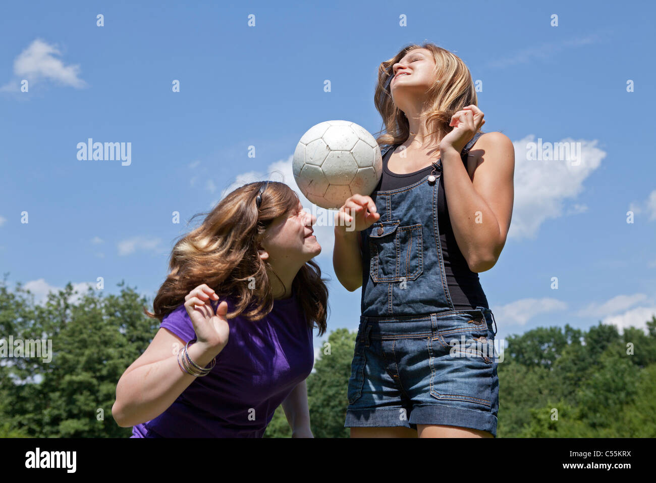 two young girls trying to head a football Stock Photo - Alamy