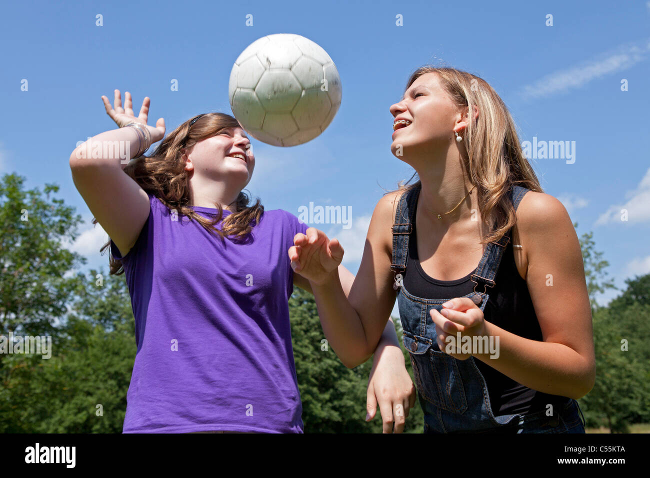 two young girls trying to head a football Stock Photo - Alamy