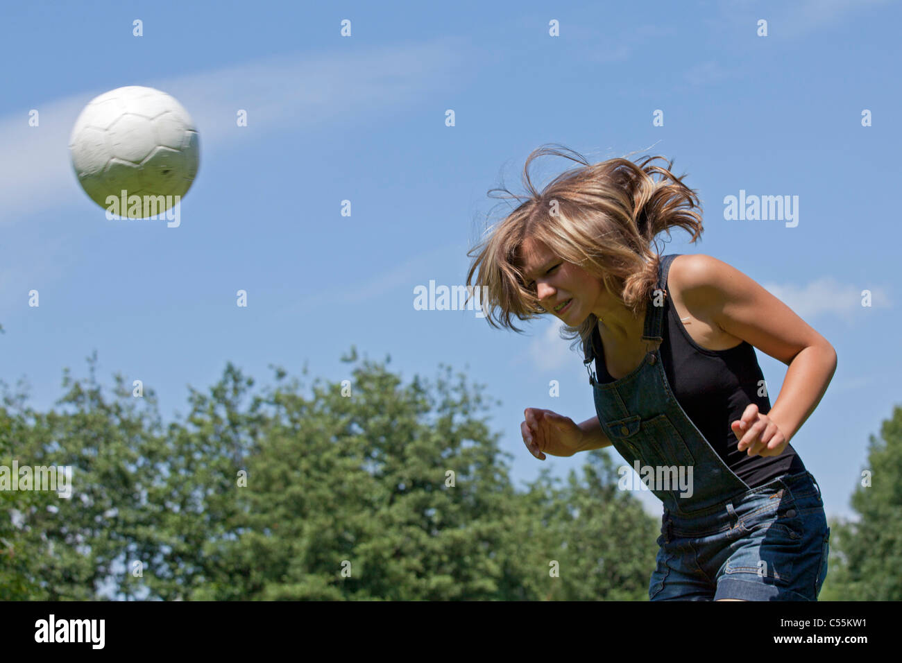 young girl heading a football Stock Photo - Alamy