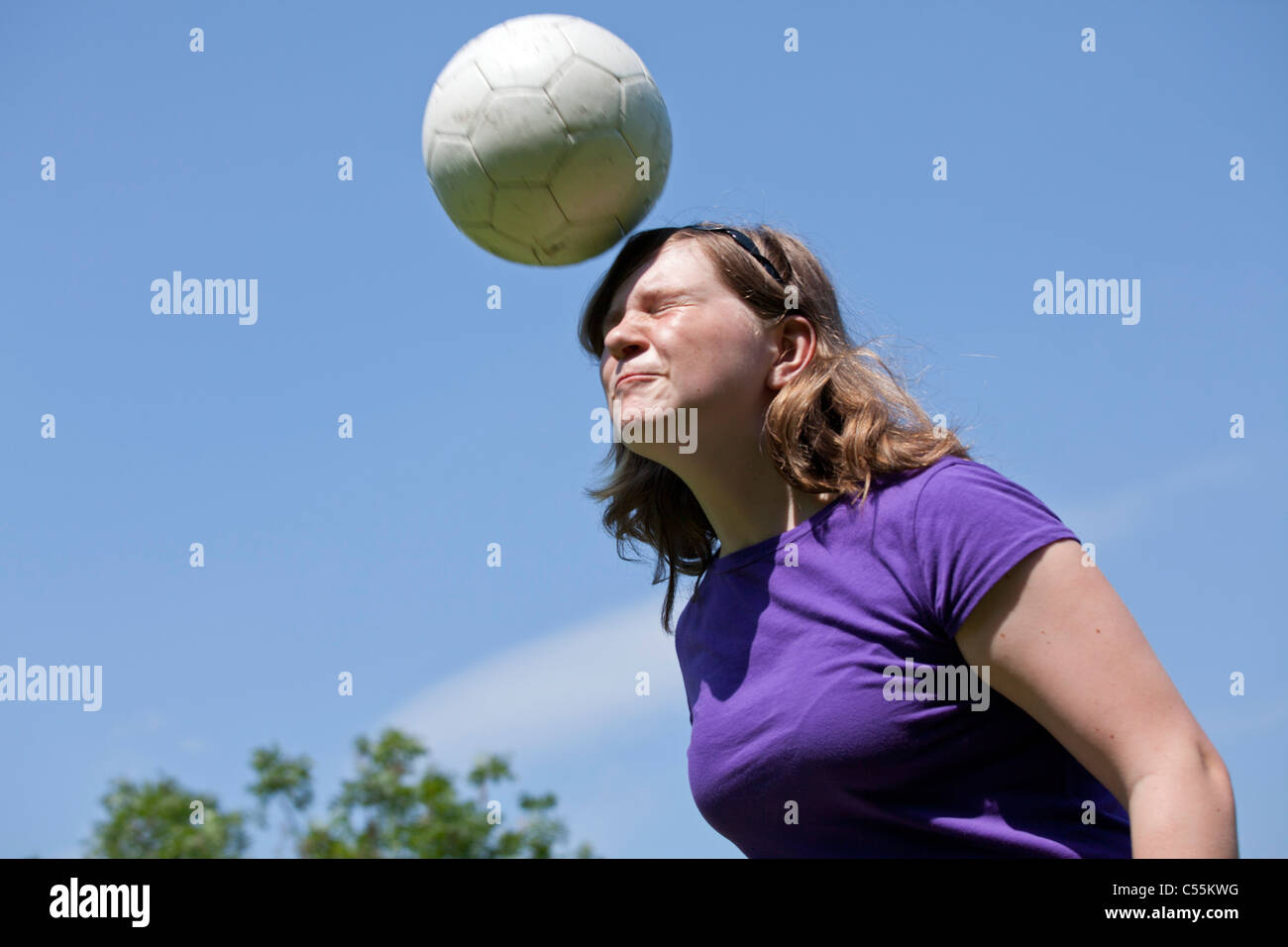 young girl heading a football Stock Photo - Alamy