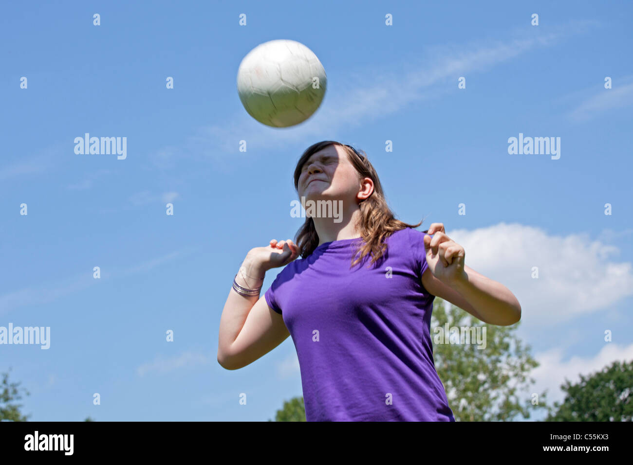 young girl heading a football Stock Photo - Alamy