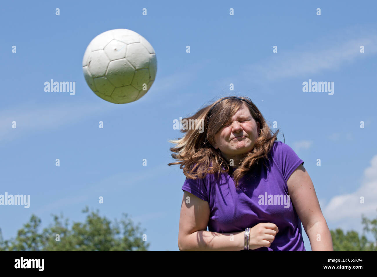 young girl heading a football Stock Photo - Alamy