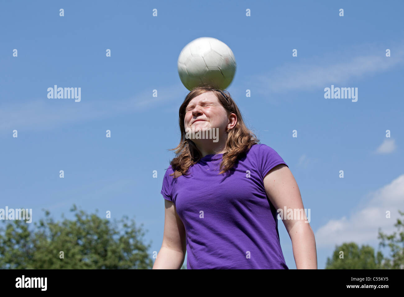 young girl heading a football Stock Photo - Alamy
