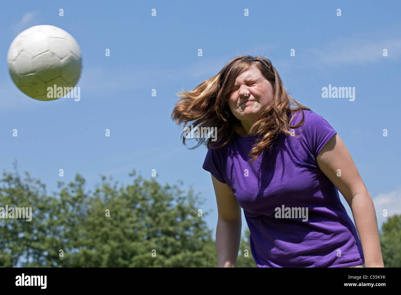 young girl heading a football Stock Photo - Alamy