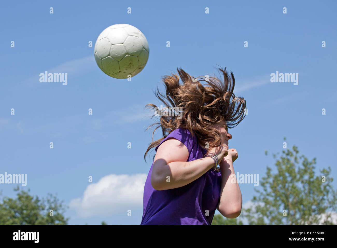 young girl heading a football Stock Photo - Alamy