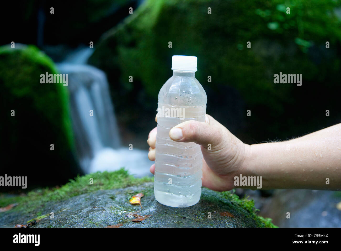 hand grabs a water bottle Stock Photo - Alamy