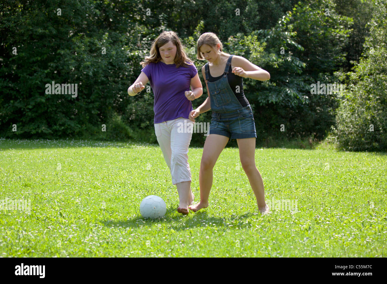 two young girls playing football Stock Photo - Alamy