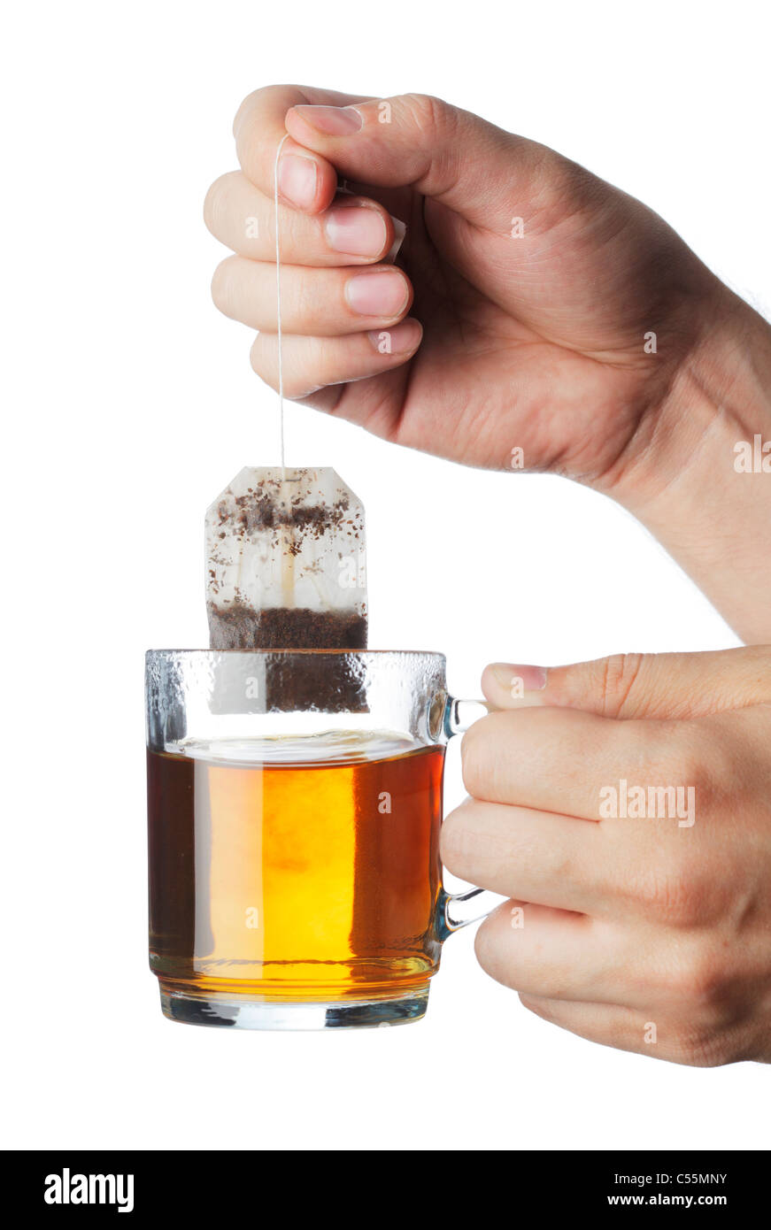 Hand lifting an used tea bag from a transparent tea mug Stock Photo - Alamy