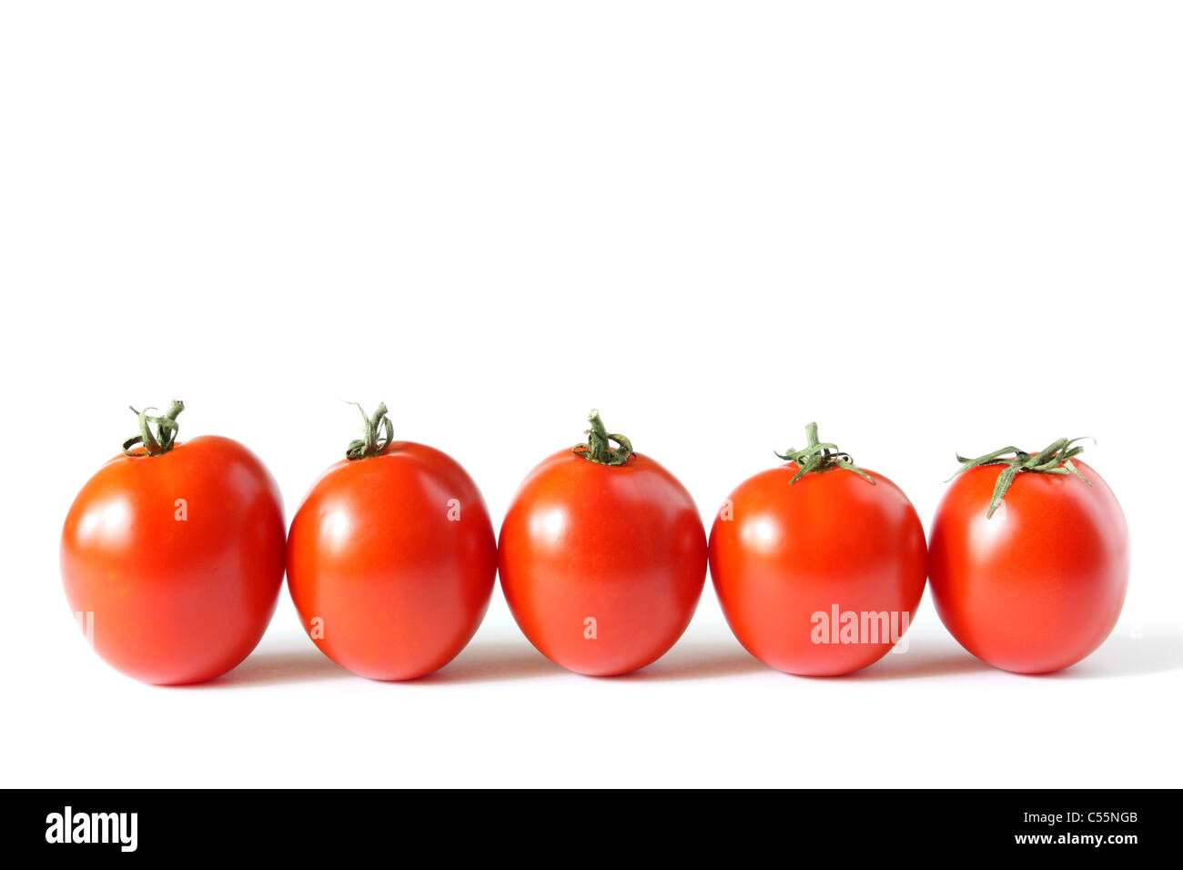 Five red tomatoes standing in a row on a white background Stock Photo ...
