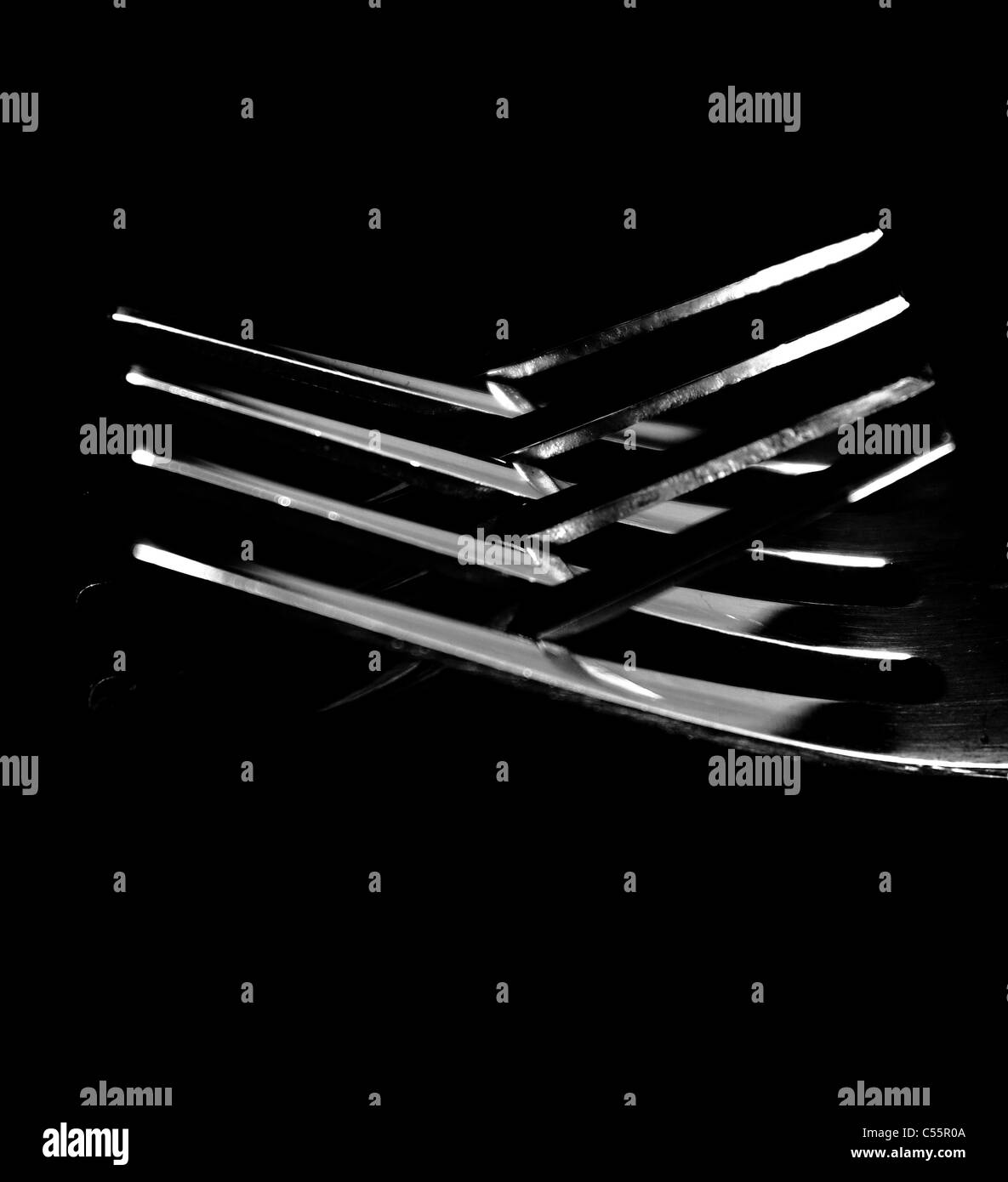 Two Forks Intertwined on a black background Stock Photo - Alamy