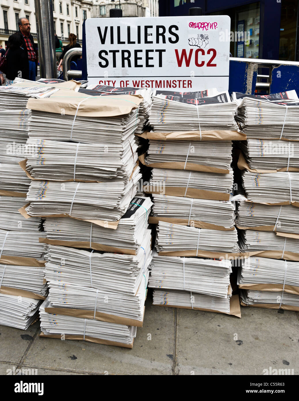 Evening Standard newspapers stacked on the corner of Villiers Street in ...