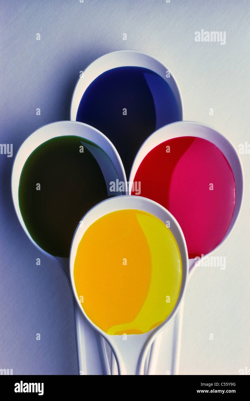 Spoons filled with colorful syrup Stock Photo - Alamy