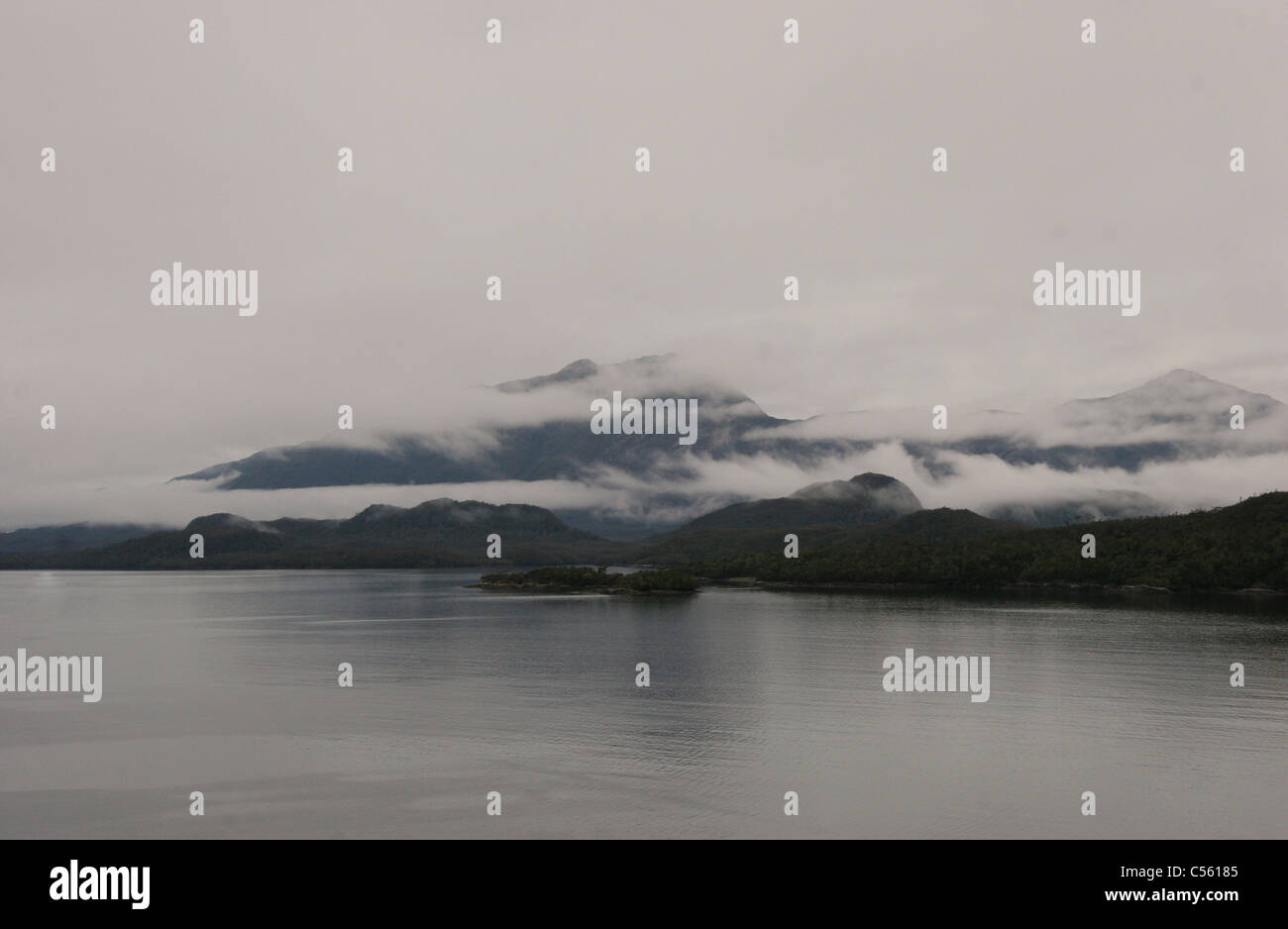 Clouds over mountain range at ocean side, Darwin Channel, Patagonia ...