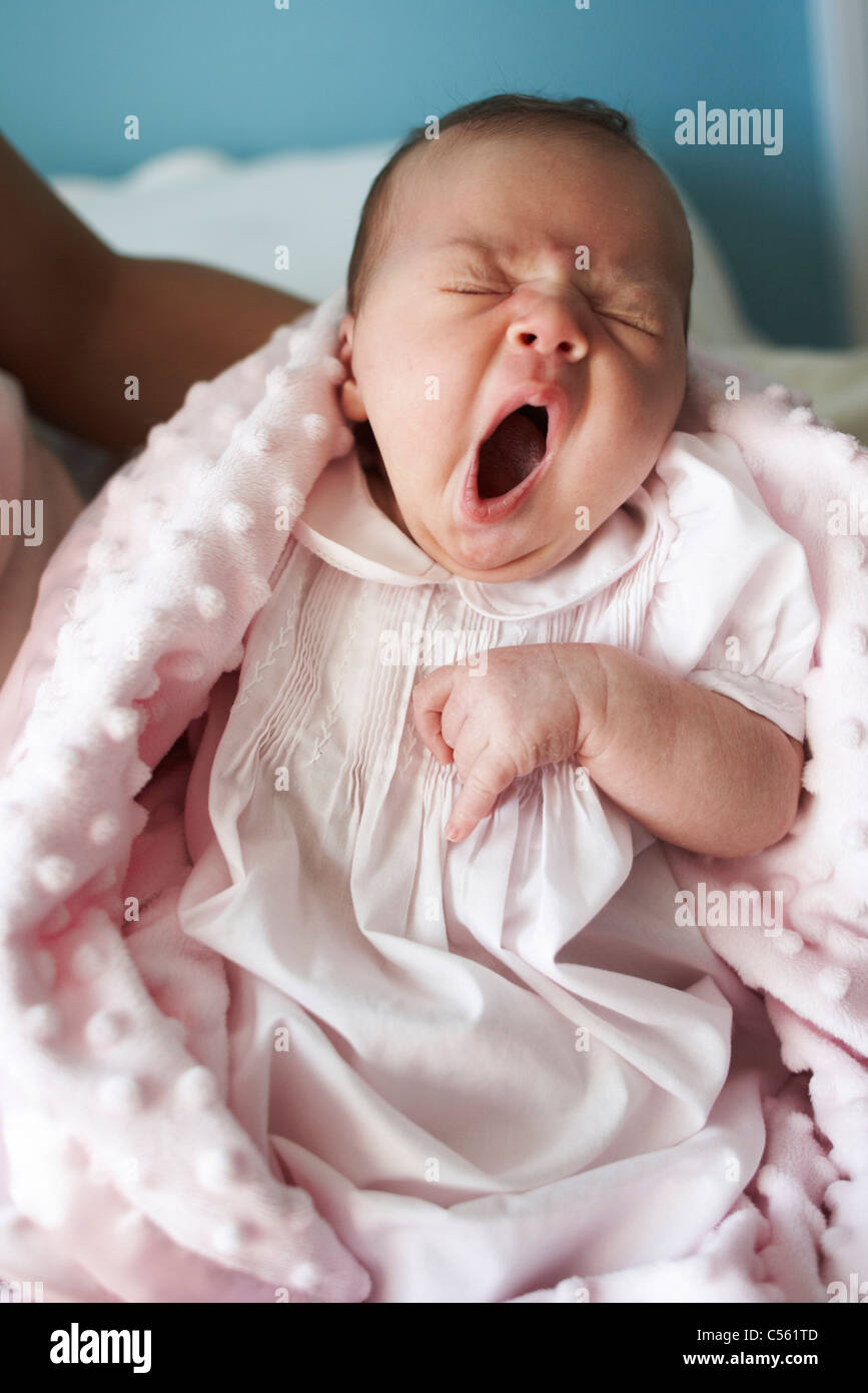 Tired baby yawning in mother's arms Stock Photo - Alamy