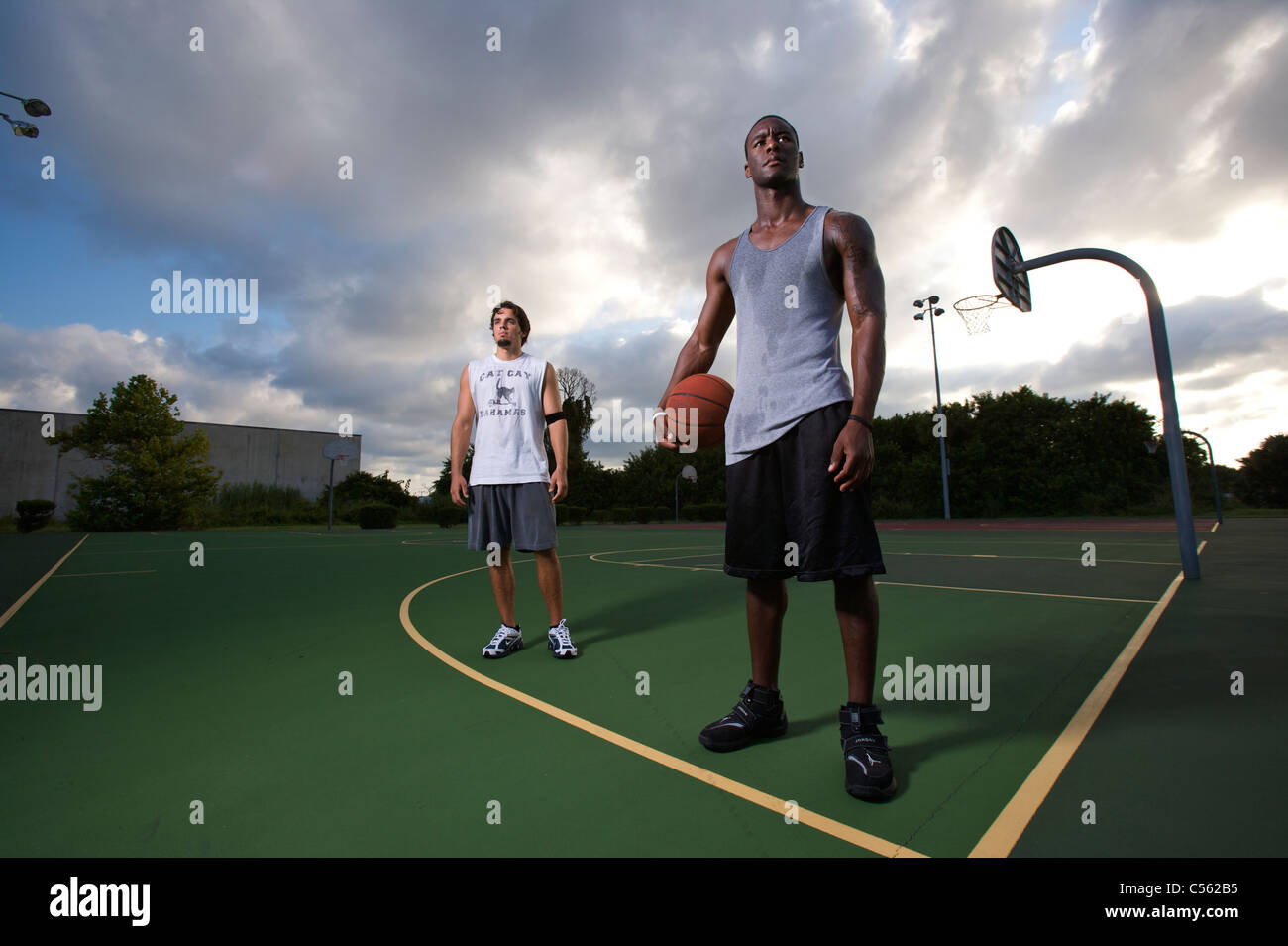 males after after playing basketball on outdoor court, dramatic sky ...
