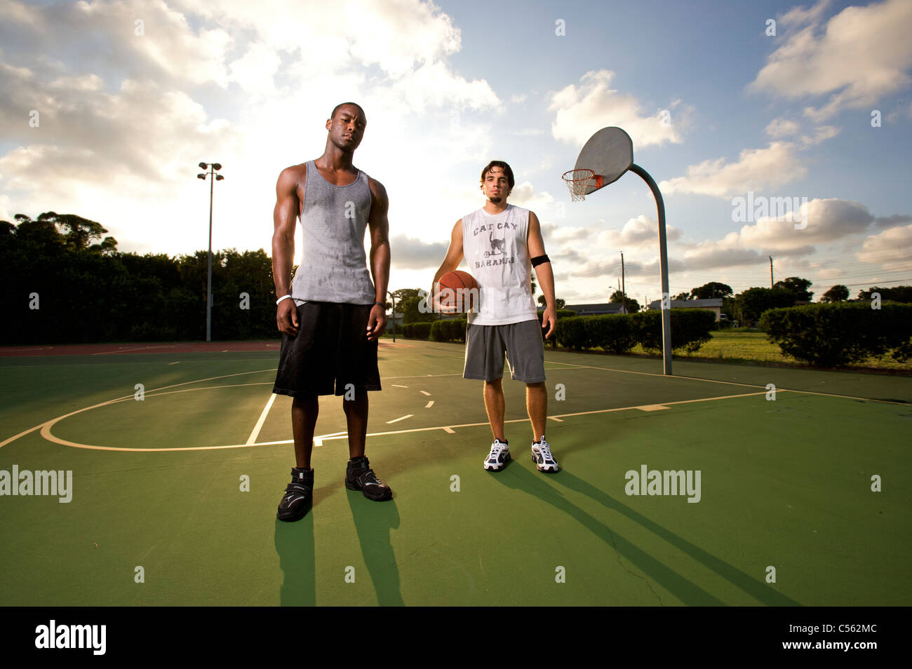 males after after playing basketball on outdoor court, dramatic sky ...
