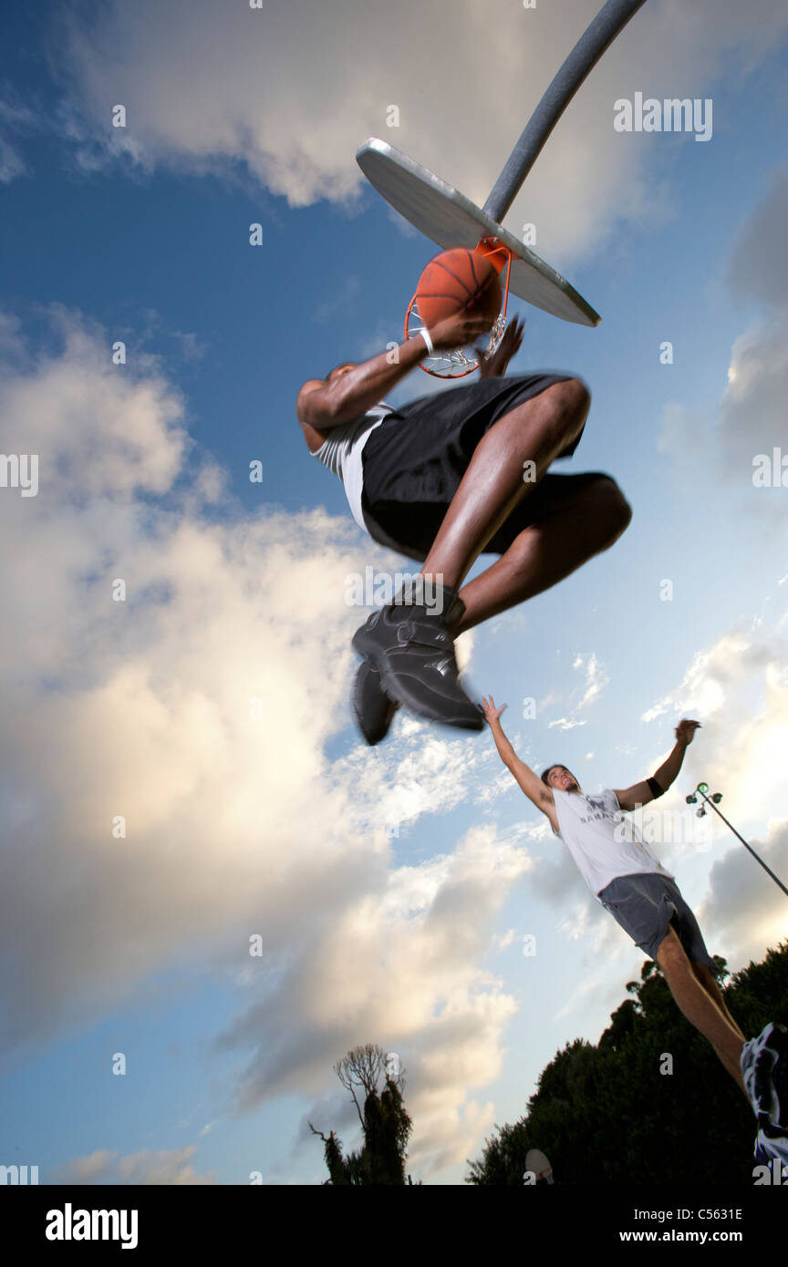 male scoring during outdoor basketball game, viewed from underneath ...