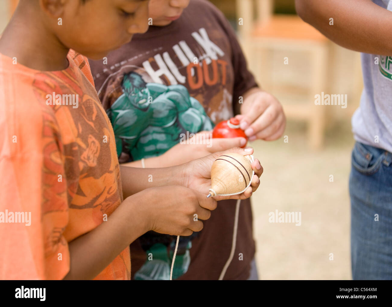 Young Colombian boys twist on strings on their toy tops Stock Photo - Alamy