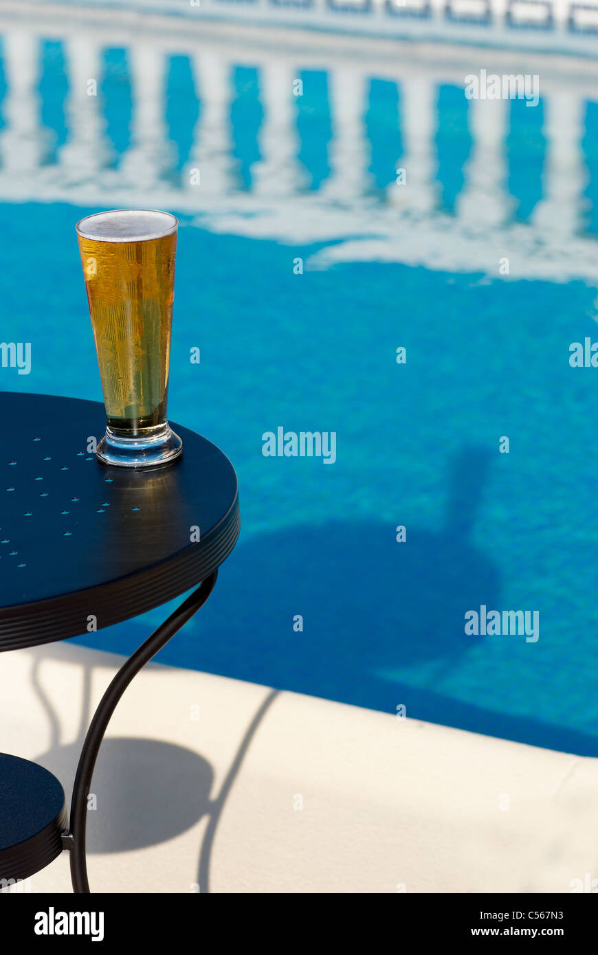 Chilled beer on a table next to a swimming pool Stock Photo - Alamy