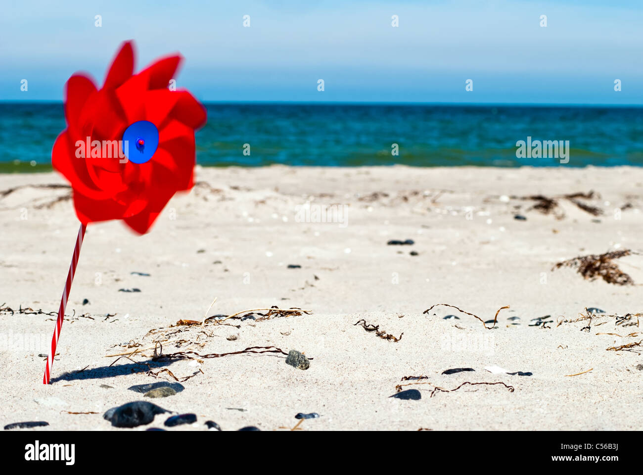 a red wind turbine on the sandy beach with sea in the background Stock ...