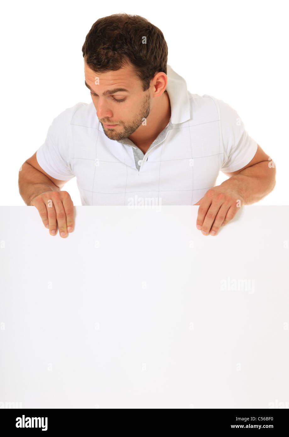 Attractive young guy standing behind white wall. All on white ...