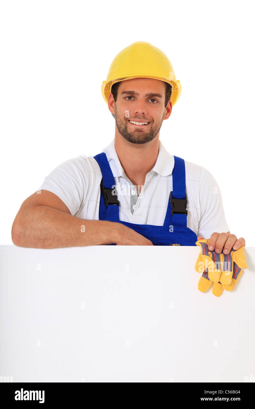 Manual worker standing behind blank white sign. All on white background ...