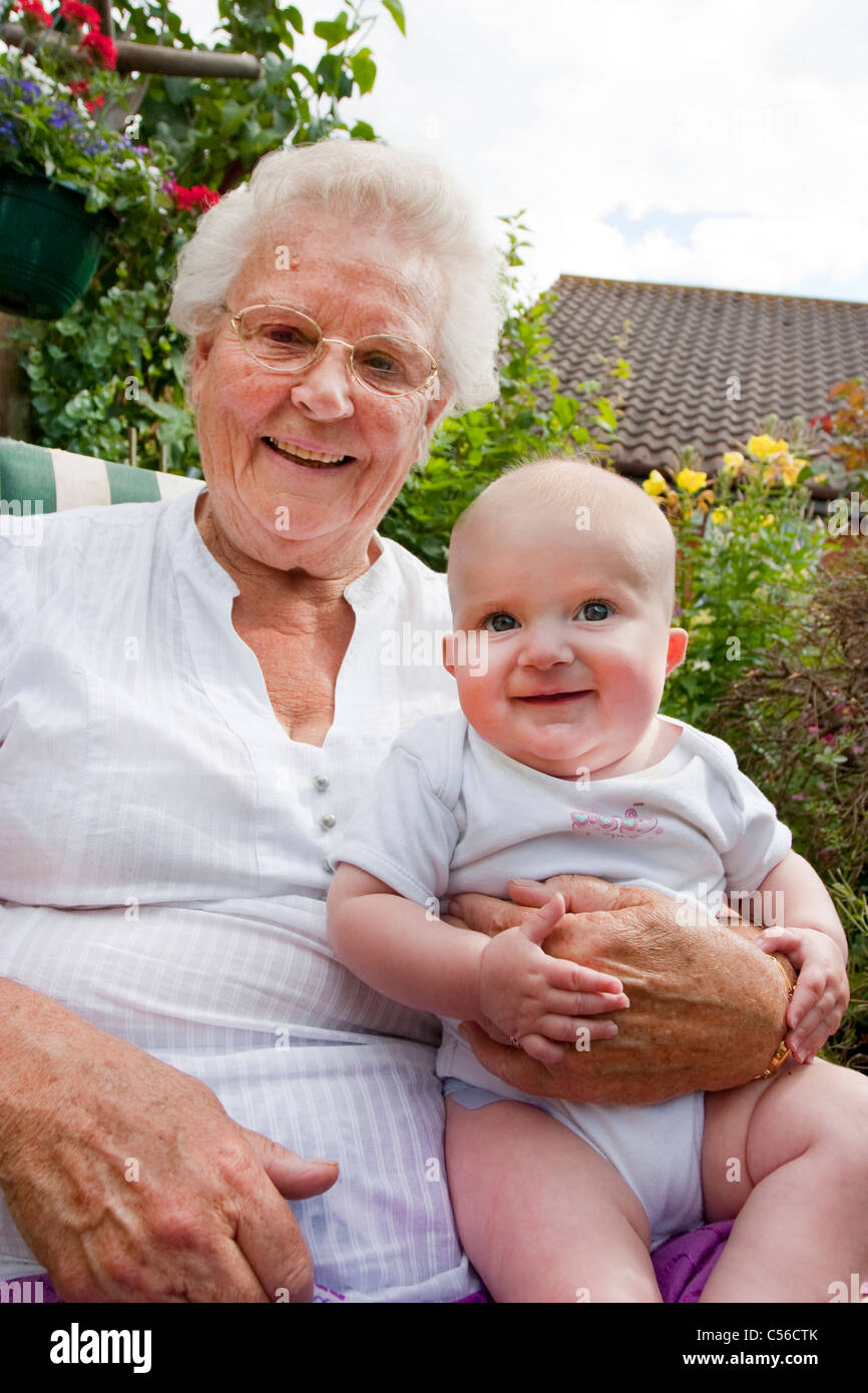 gran and grand daughter sitting in the garden smiling Stock Photo - Alamy