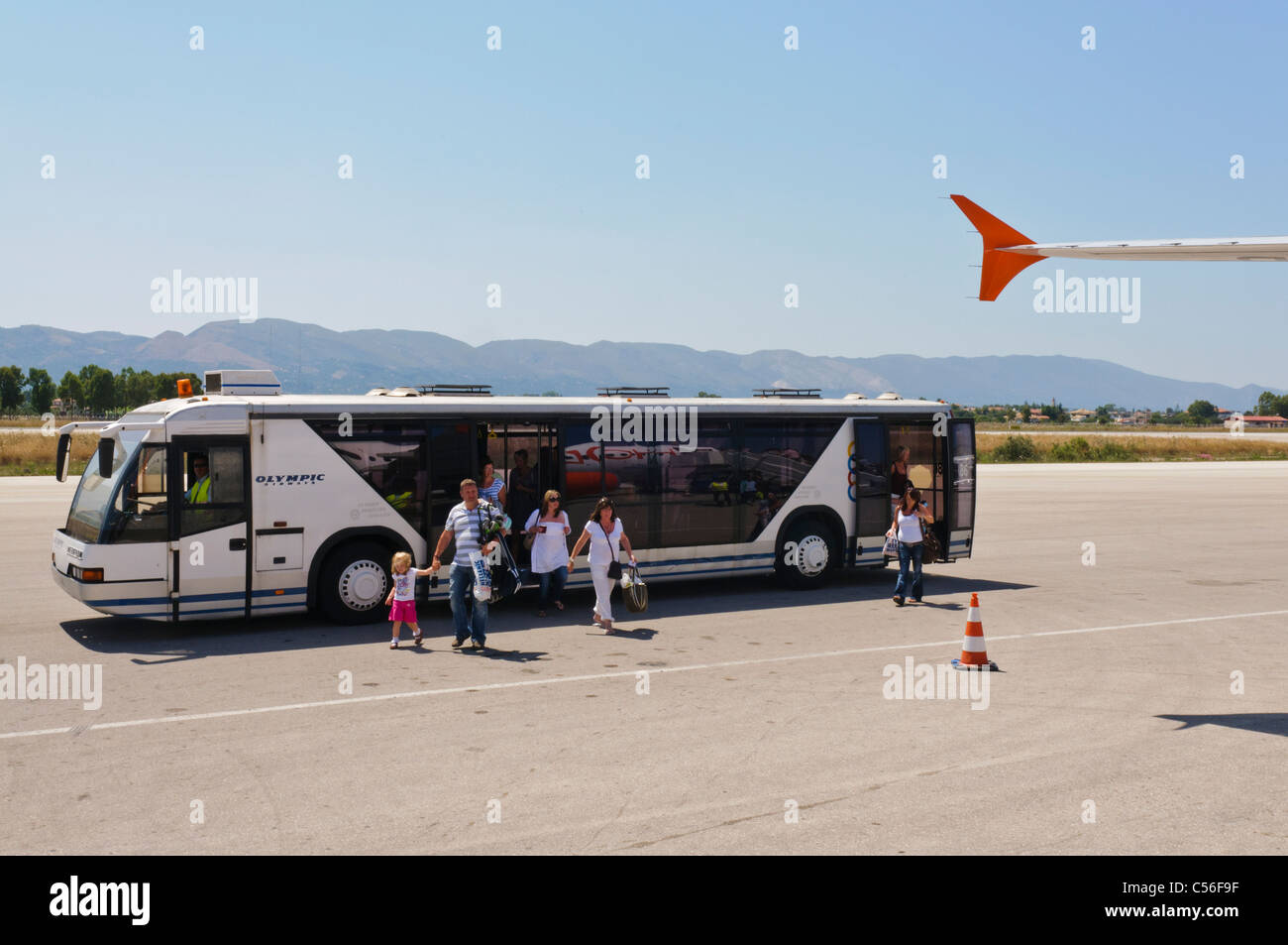 People leaving an airport passenger transfer bus about to board a plane ...